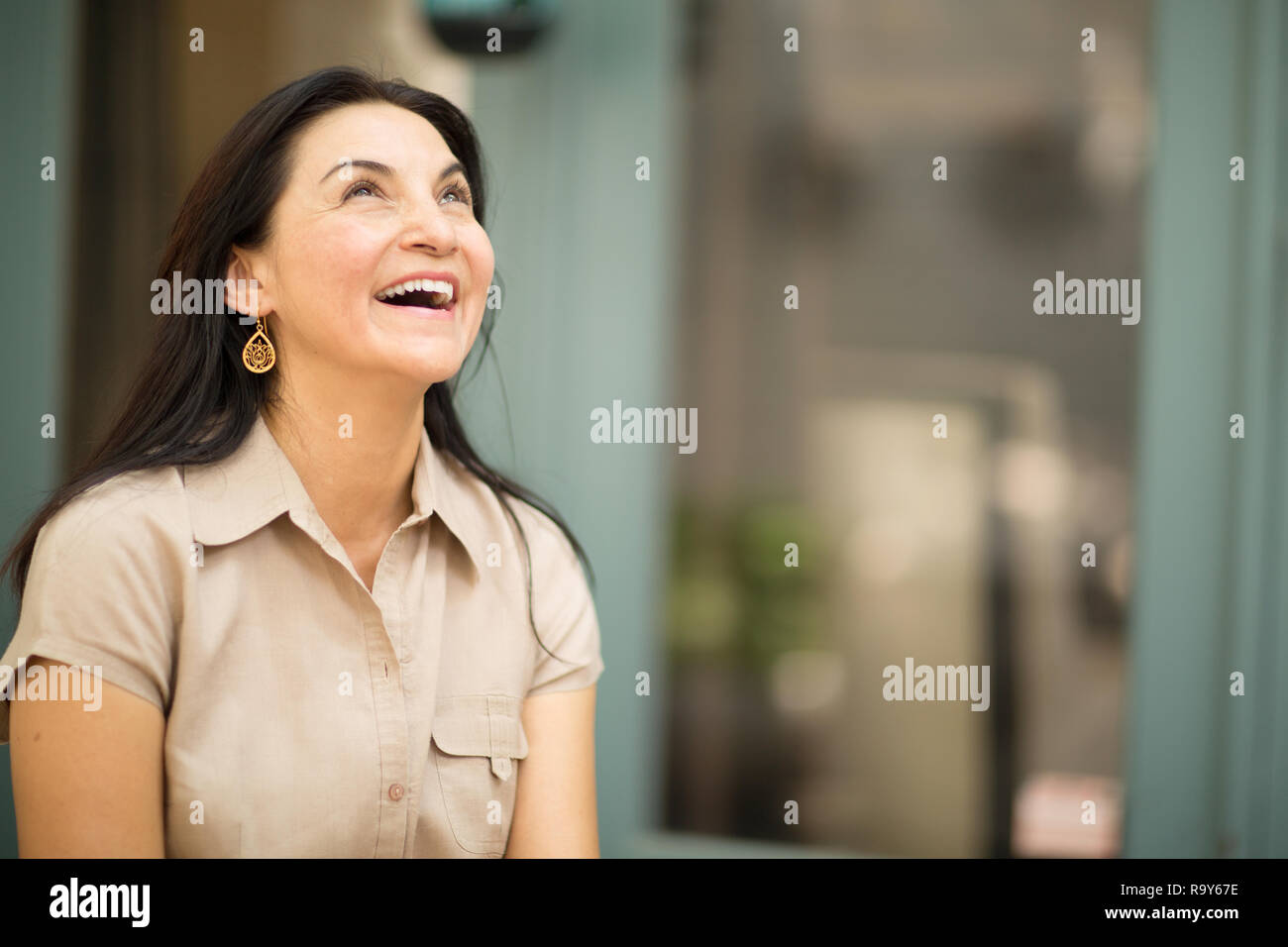 Happy Hispanic woman smiling and standing outside Stock Photo - Alamy