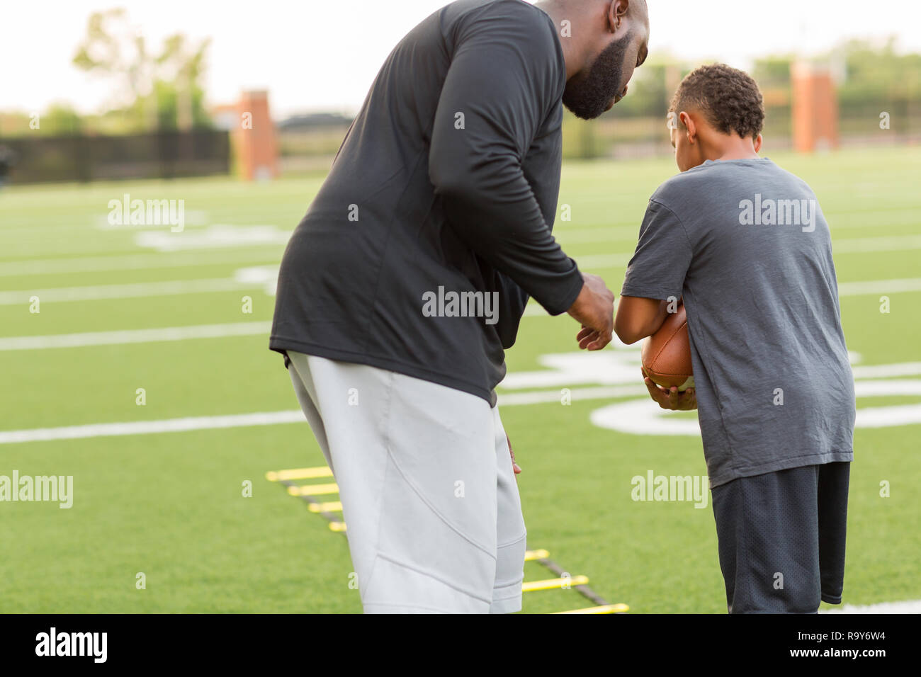 American Football coach training a young athlete Stock Photo - Alamy