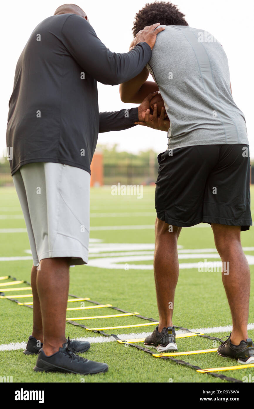 American Football coach training a young athlete Stock Photo - Alamy