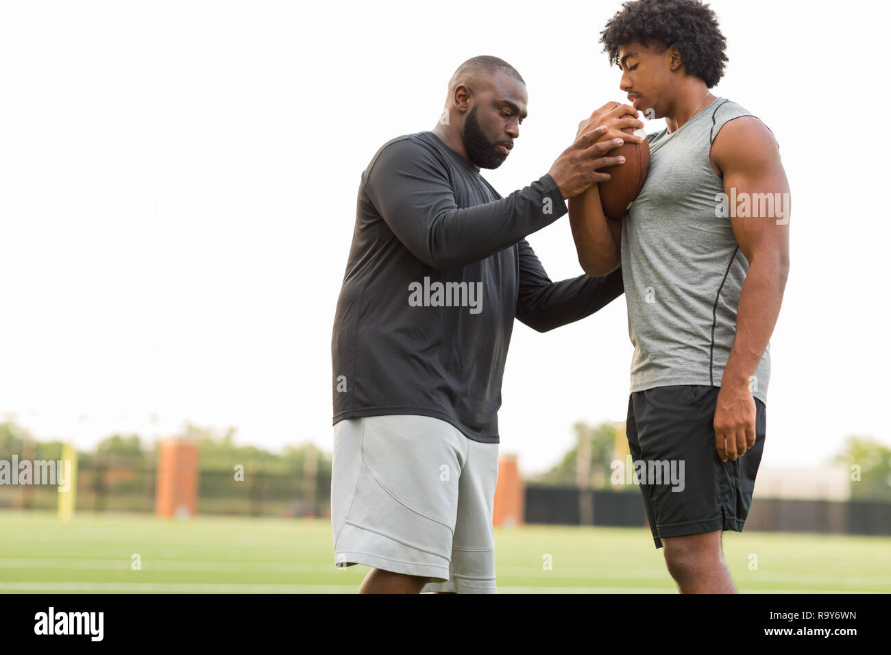 American Football coach training a young athlete Stock Photo - Alamy