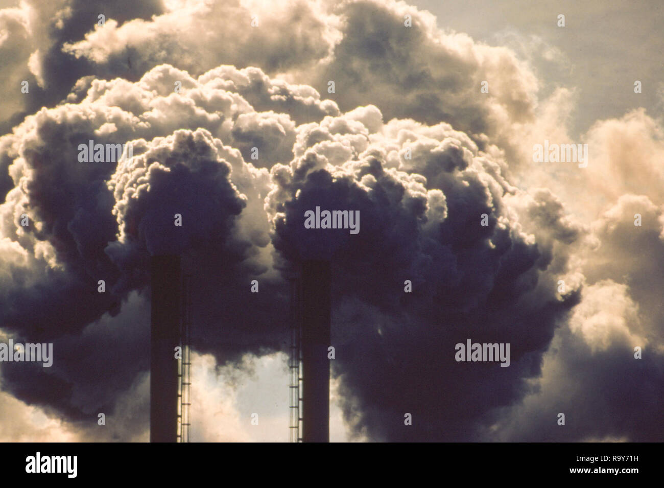 Black smoke bellows from industrial smokestacks 1972 Stock Photo - Alamy