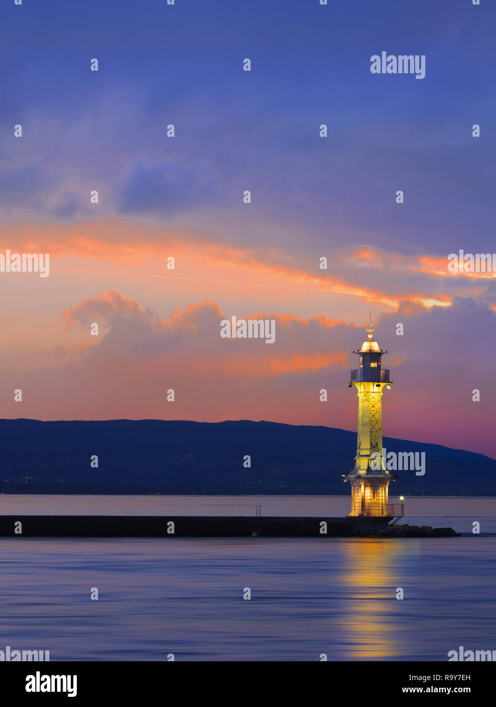 Antique lighthouse at multicolored dramatic sunset, Lake Geneva ...