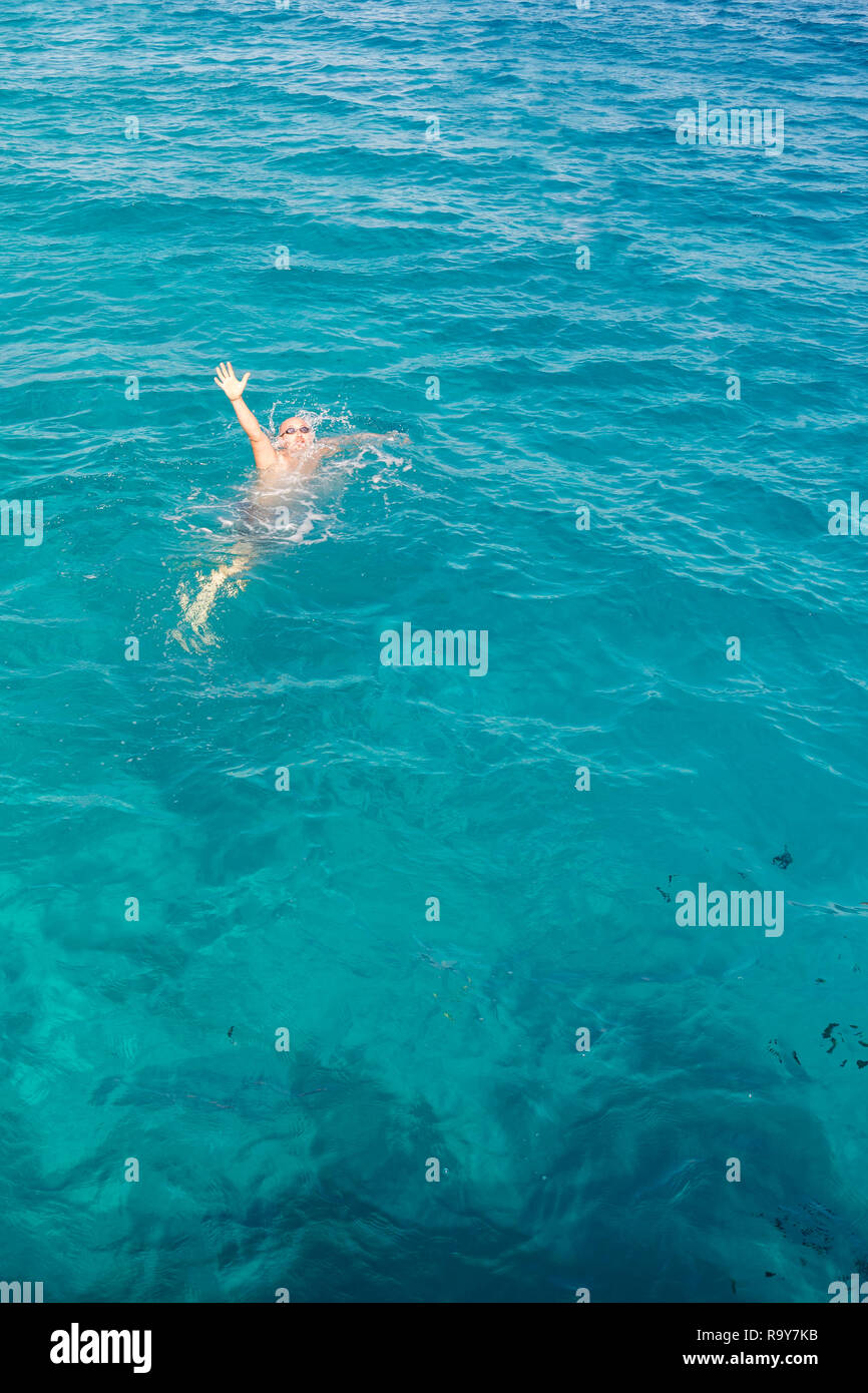 Drowning man in sea asking for help with raised arms. The man is ...
