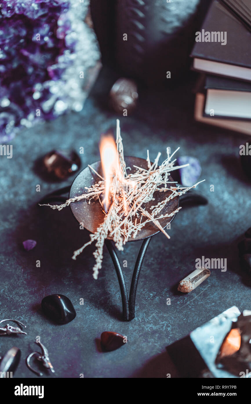 Burning herbs on a witch's altar for a magical ritual among crystals ...