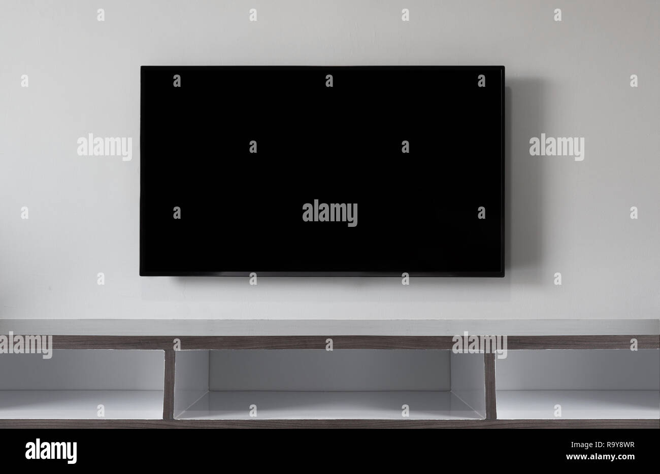 Widescreen television on white wall Stock Photo - Alamy