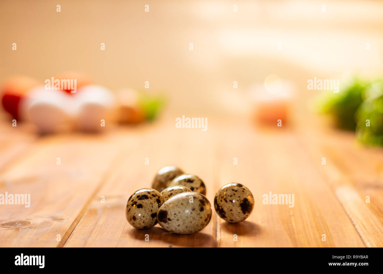 Quail eggs on a rustic table. Some kitchen elements out of focus on a ...