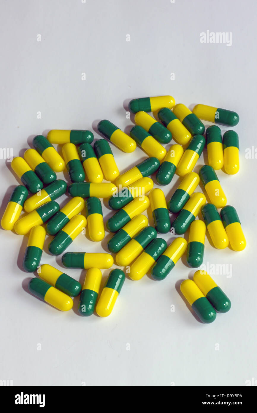 green yellow capsule drug isolated white background Stock Photo - Alamy