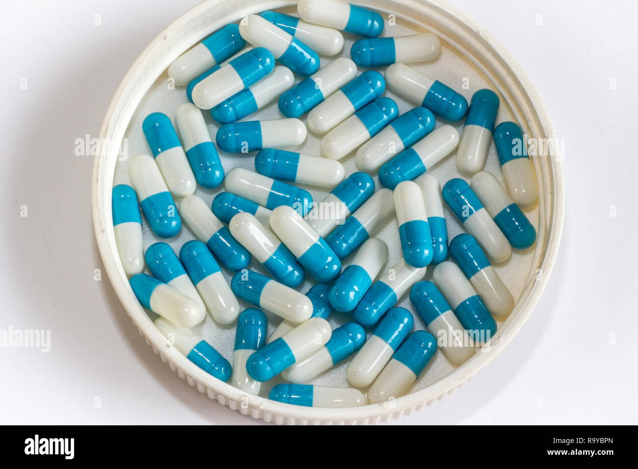 Blue white capsule drug isolated white background Stock Photo - Alamy
