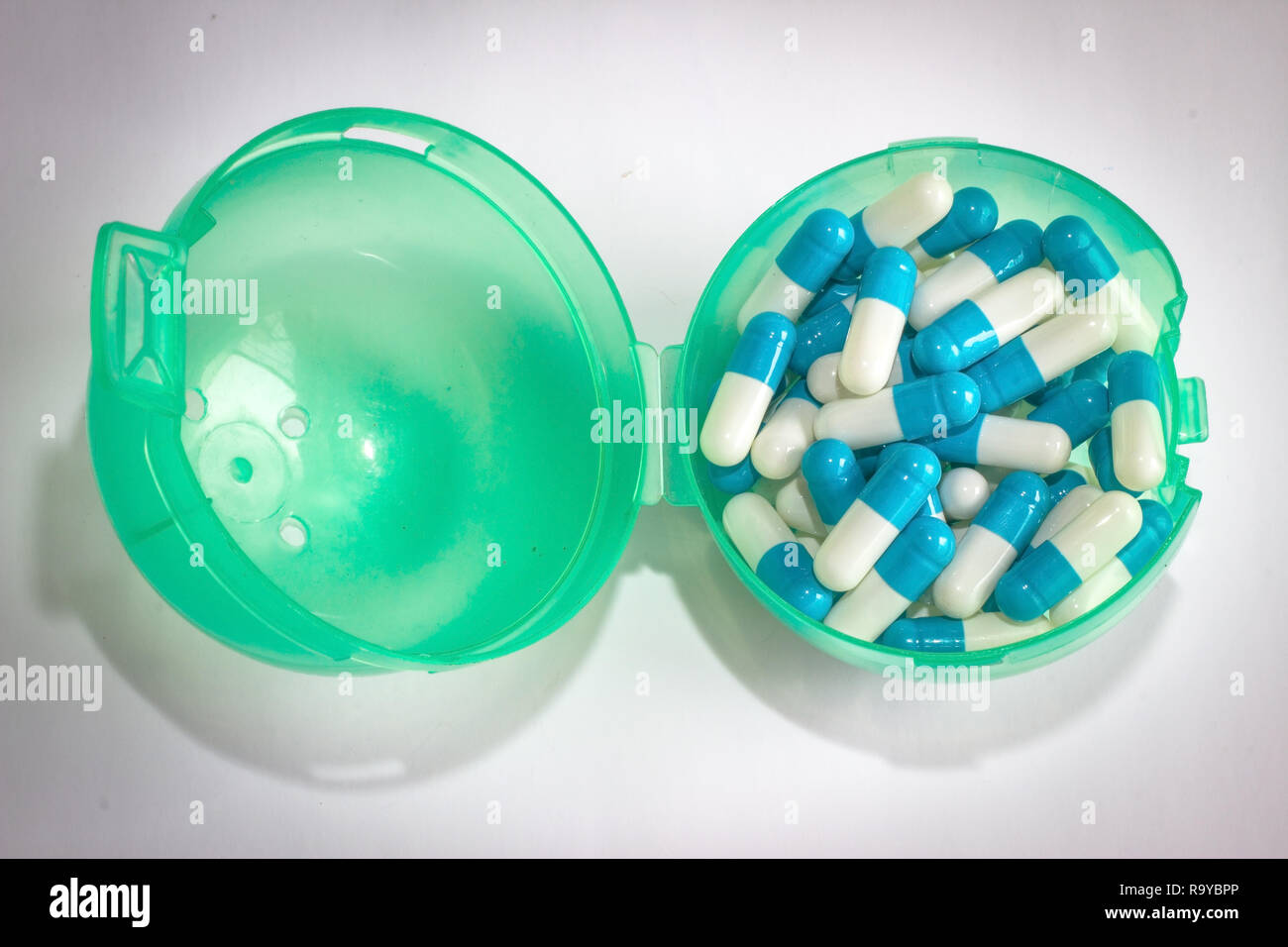 Blue white capsule drug isolated white background Stock Photo - Alamy