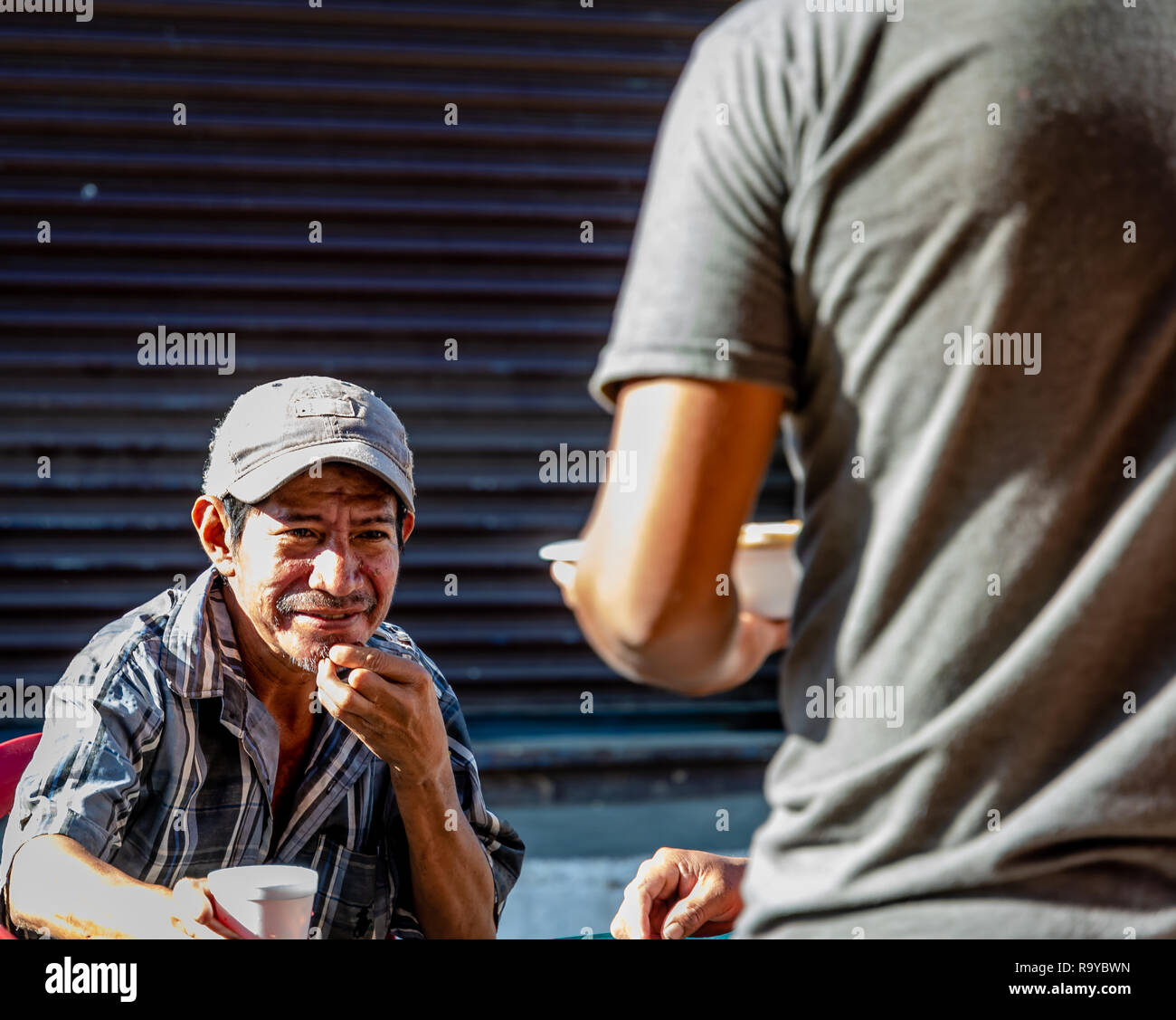 homeless man eating food on street in Guatemala Stock Photo - Alamy