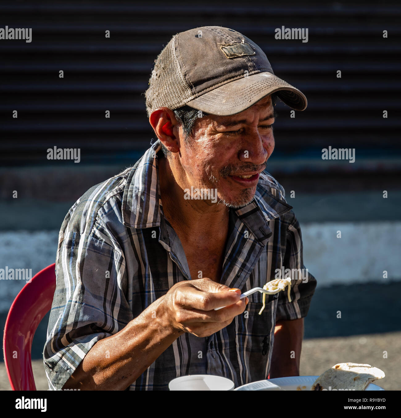 homeless man eating food on street in Guatemala Stock Photo - Alamy