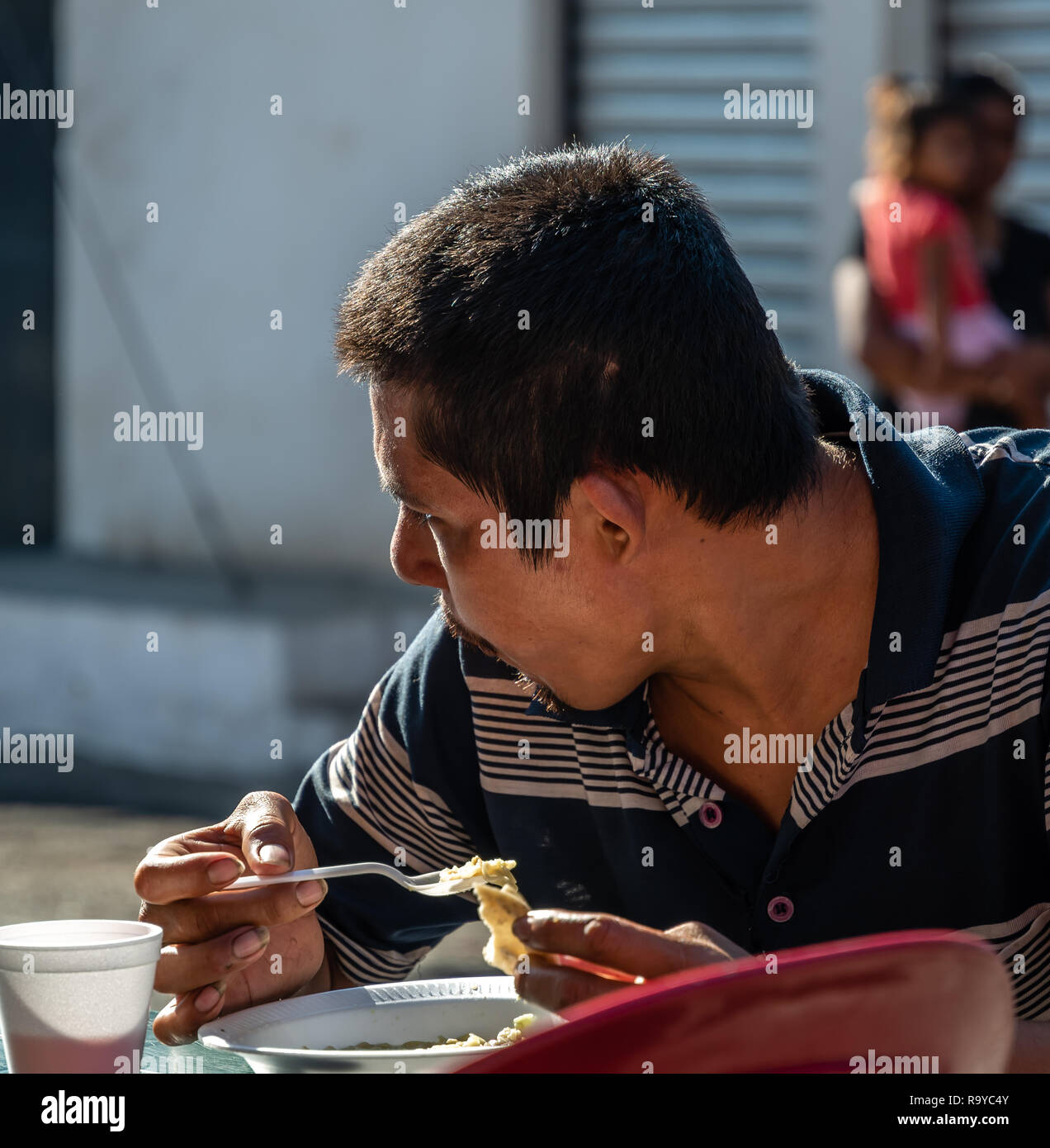 homeless man eating food on street in Guatemala Stock Photo - Alamy