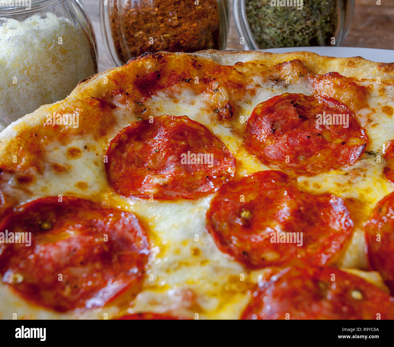 Partial pepperoni pizza with three bottles of extras. chili Spice ...