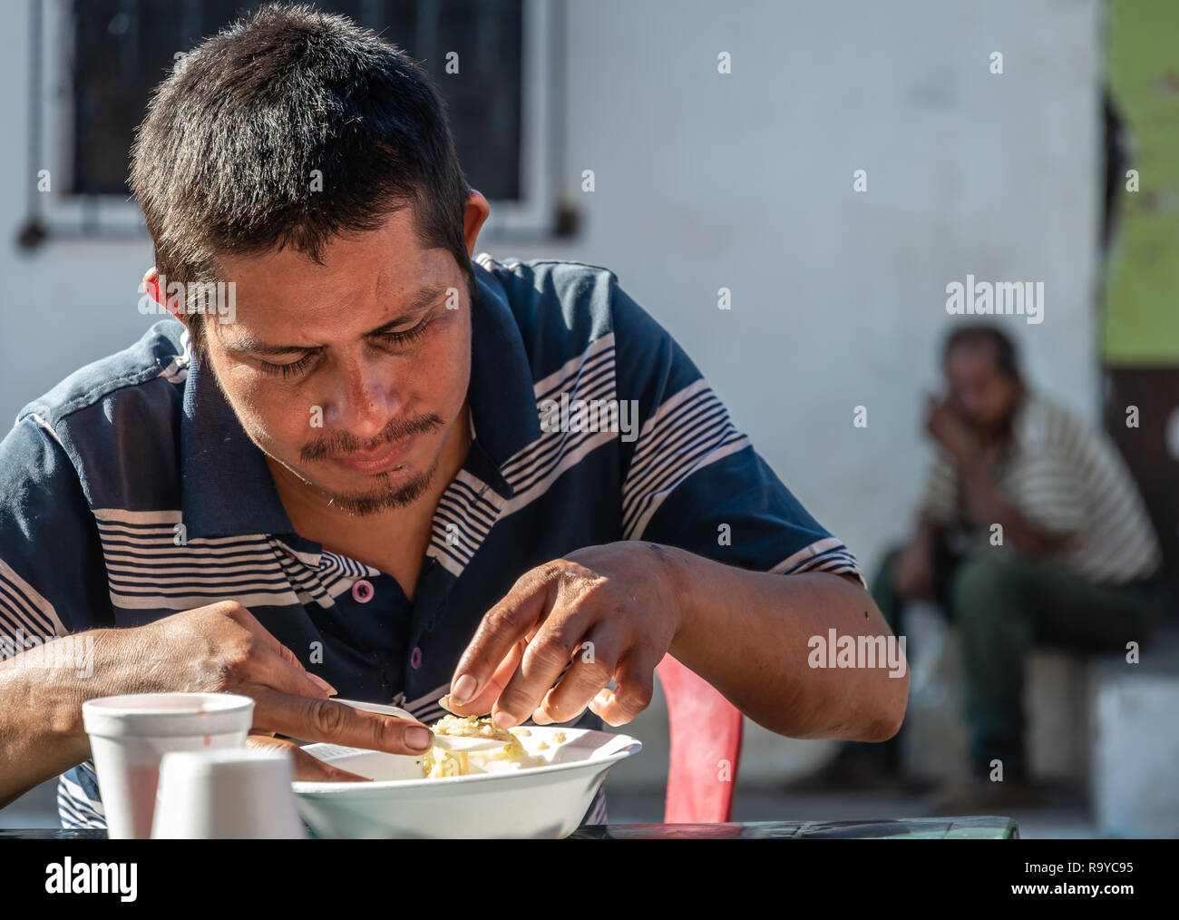 Guatemalan man eating on street Stock Photo - Alamy