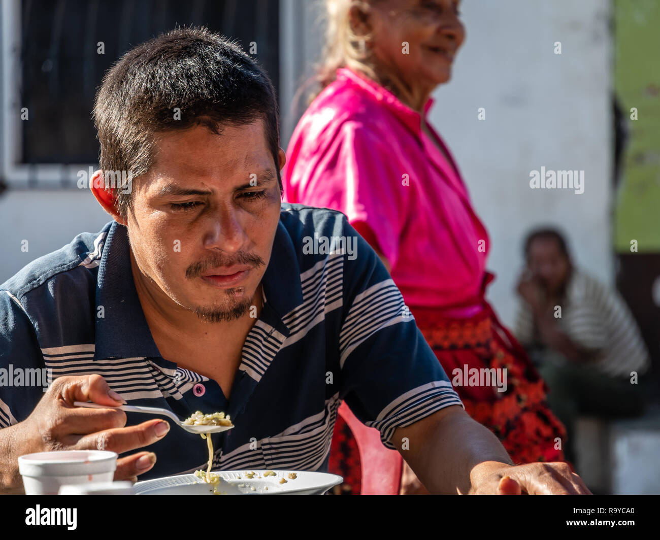 Guatemalan man eating on street Stock Photo - Alamy