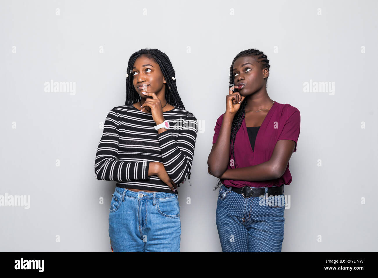 Portrait of two smiling young african women standing together bored ...