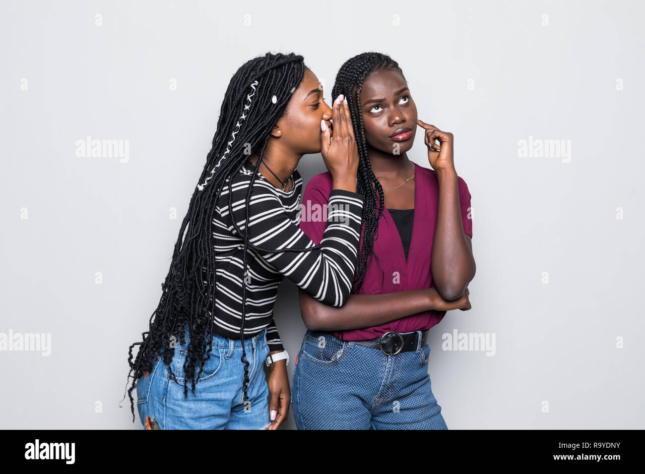 Portrait Of Two Happy Young African Women Sharing Secrets Isolated