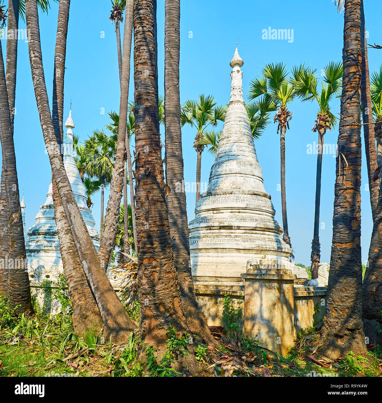 The old white pagodas of Bagaya Monastery, decorated with relief belts ...