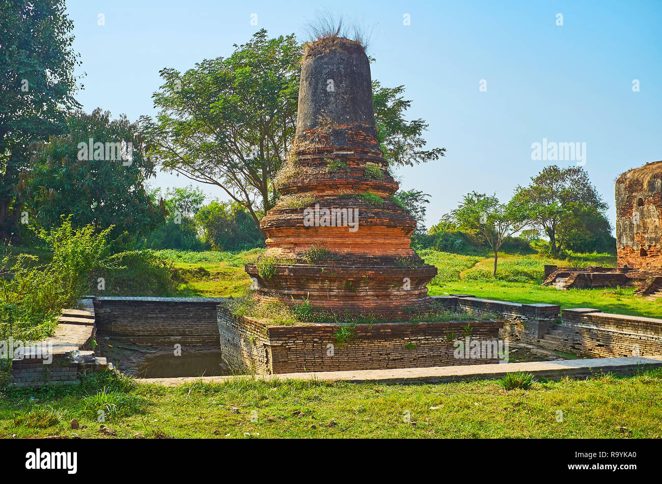 The ruins of ancient stupa located amid the small water tank next to ...
