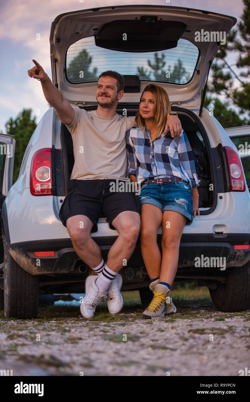 Young couple sitting on the back of a off road vehicle and enjoying the ...