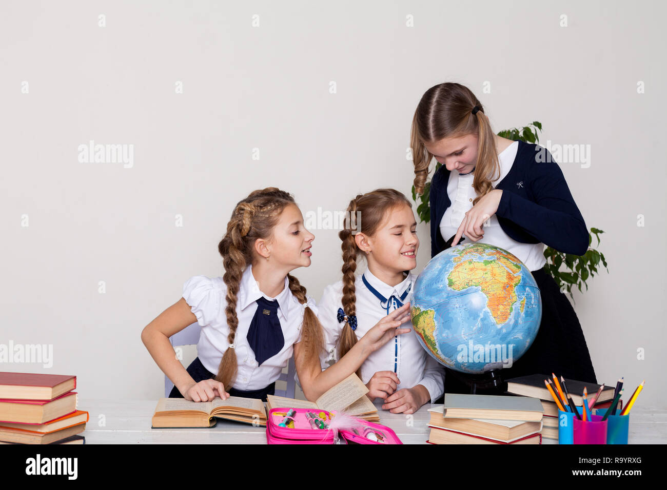 three girls in the school geography lesson learn globe knowledge Stock ...