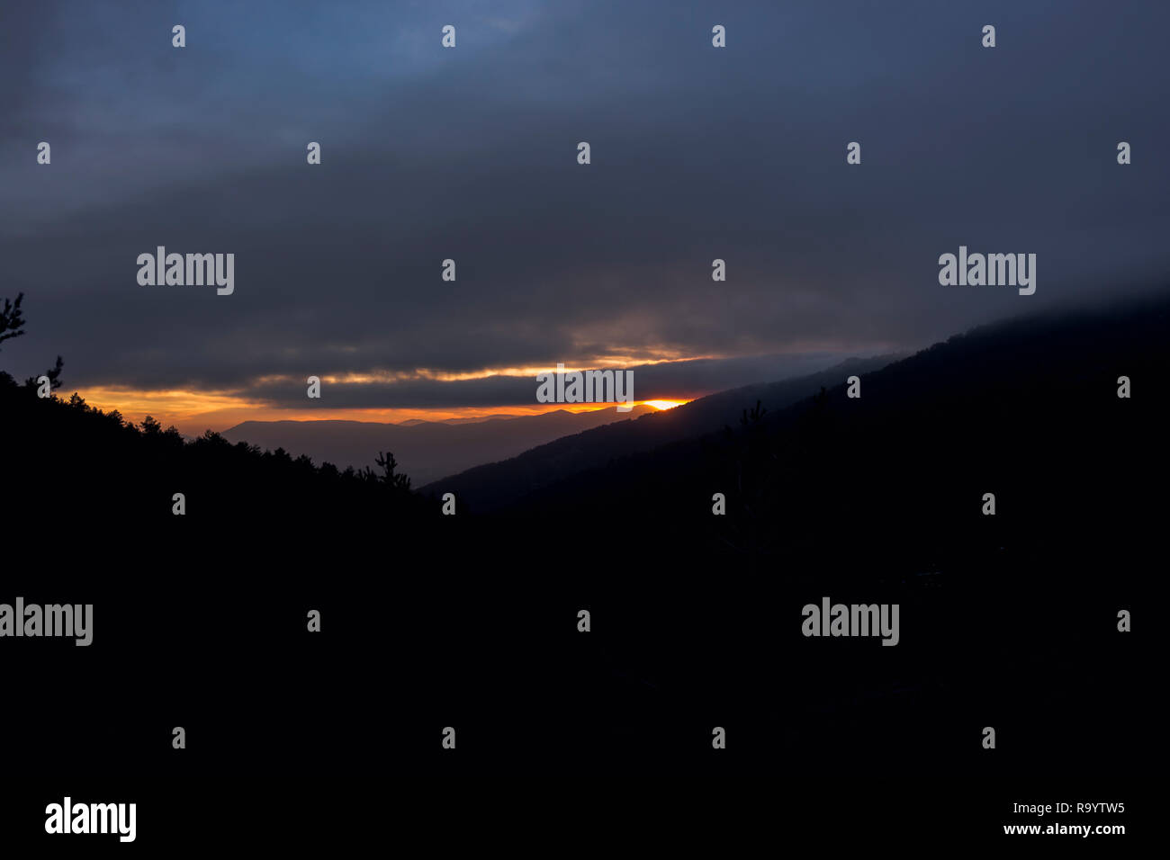 Nice sunset between mountains and wild forests Stock Photo - Alamy