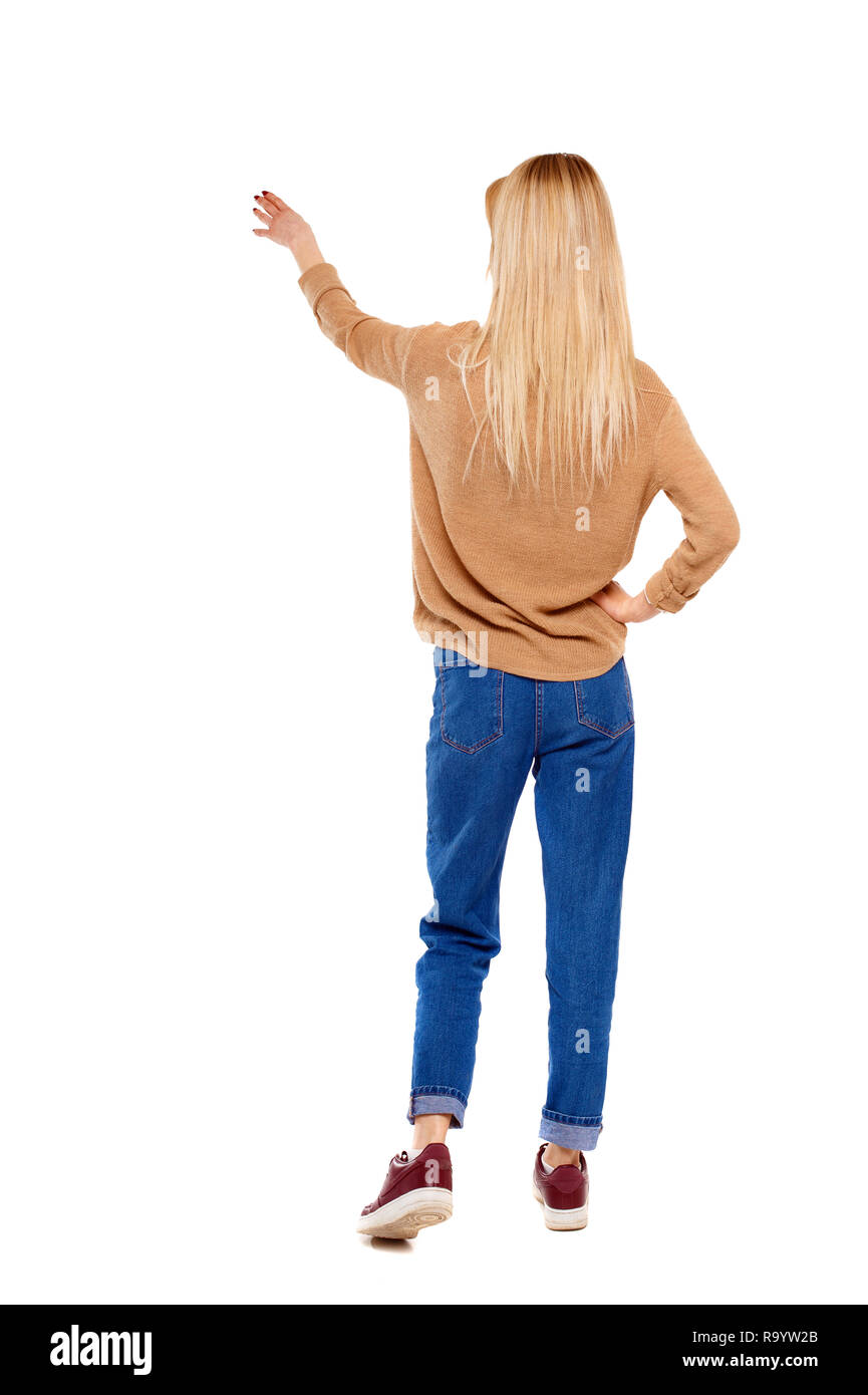 Back view of a woman in a sweater points his hand upwards. Rear view ...
