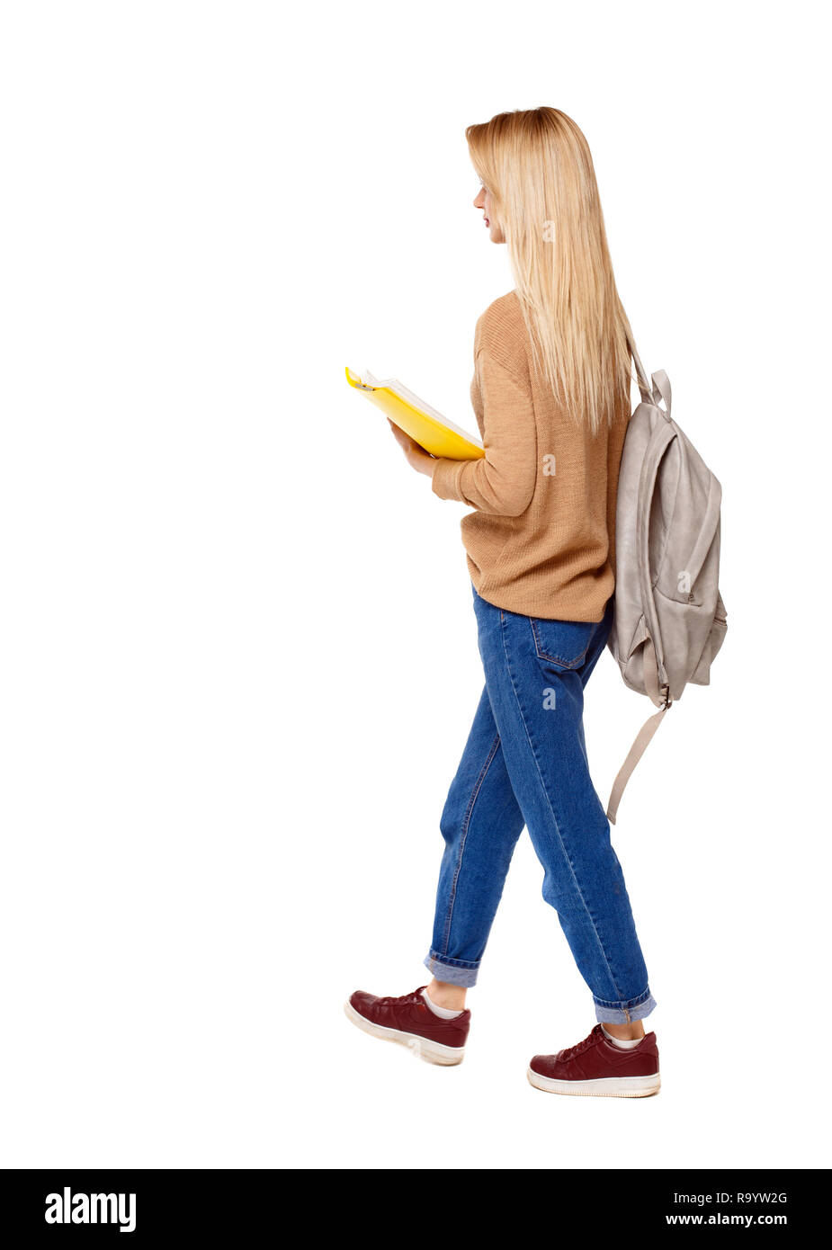 Back view of a student walking with a backpack and textbooks. backside ...