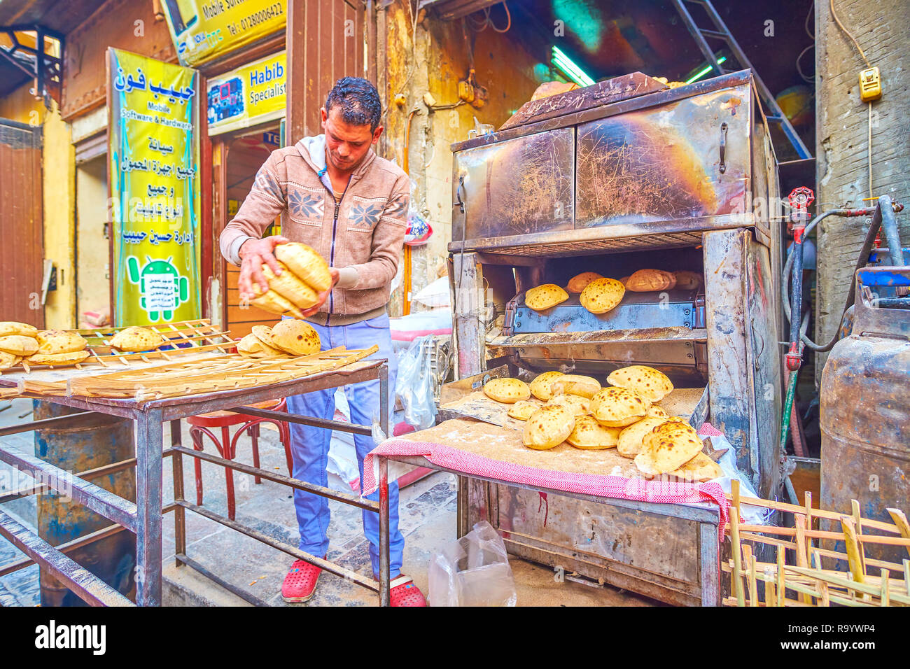 CAIRO, EGYPT - DECEMBER 20, 2017: The baker sells the hot fresh pita ...