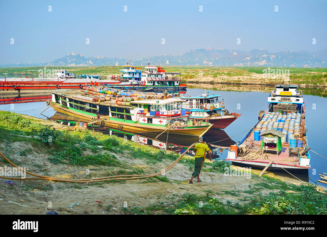 MANDALAY, MYANMAR - FEBRUARY 21, 2018: The cargo ships and barges are ...