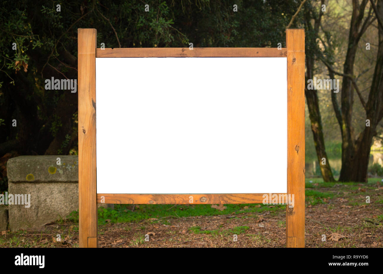 Front view of a wooden advertisement mockup at a green forest park ...