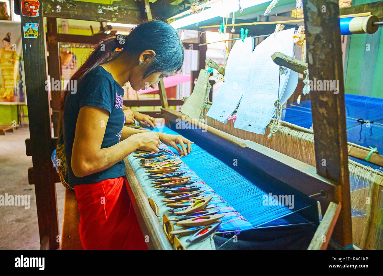 MANDALAY, MYANMAR - FEBRUARY 21, 2018: The artisans make silk fabric ...