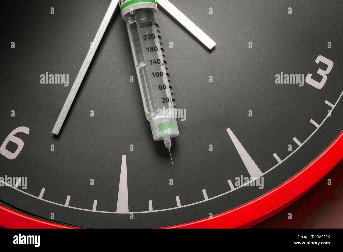 medicine vials and syringe, the clock shows the time of the medication ...