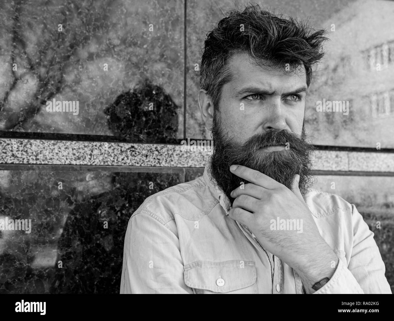 Masculinity concept. Hipster with tousled hair touches beard while ...