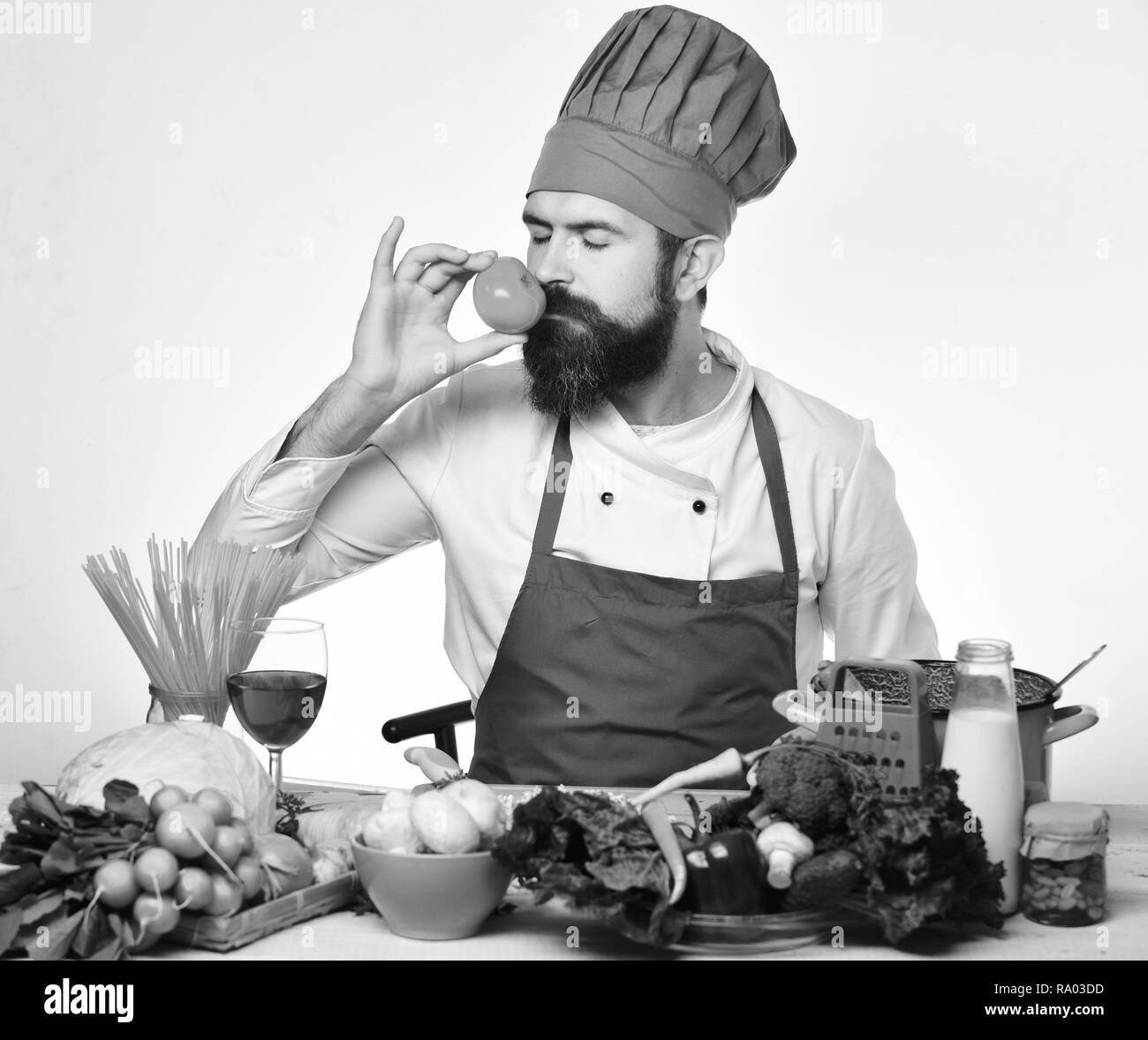 Professional cookery concept. Cook with dreamy face in burgundy uniform ...