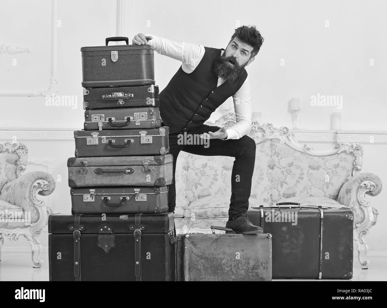 Man, butler with beard and mustache delivers luggage, luxury white ...