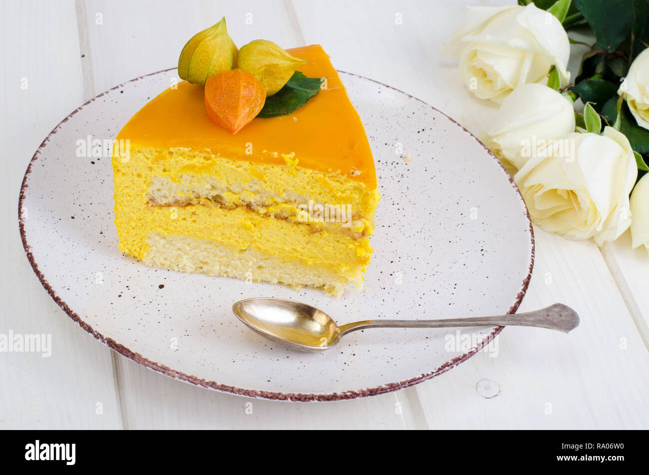 Piece of mango mousse cake on plate, white wooden table. Studio Photo ...