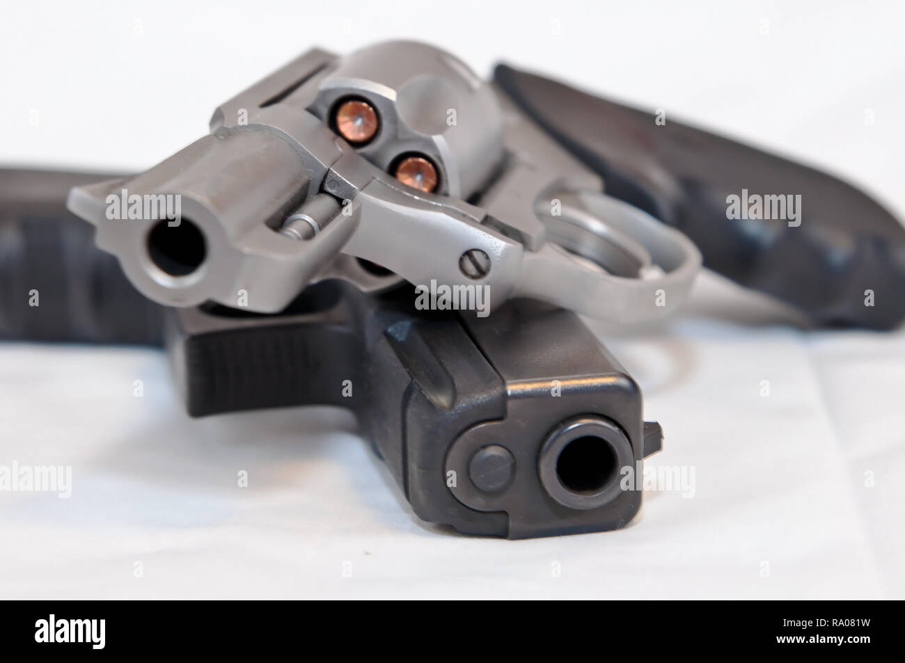 Two handguns, a silver 357 magnum revolver on top of a black 9mm pistol ...