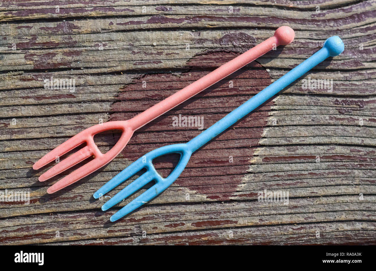 Two plastic forks over an engraved heart on wooden surface Stock Photo ...