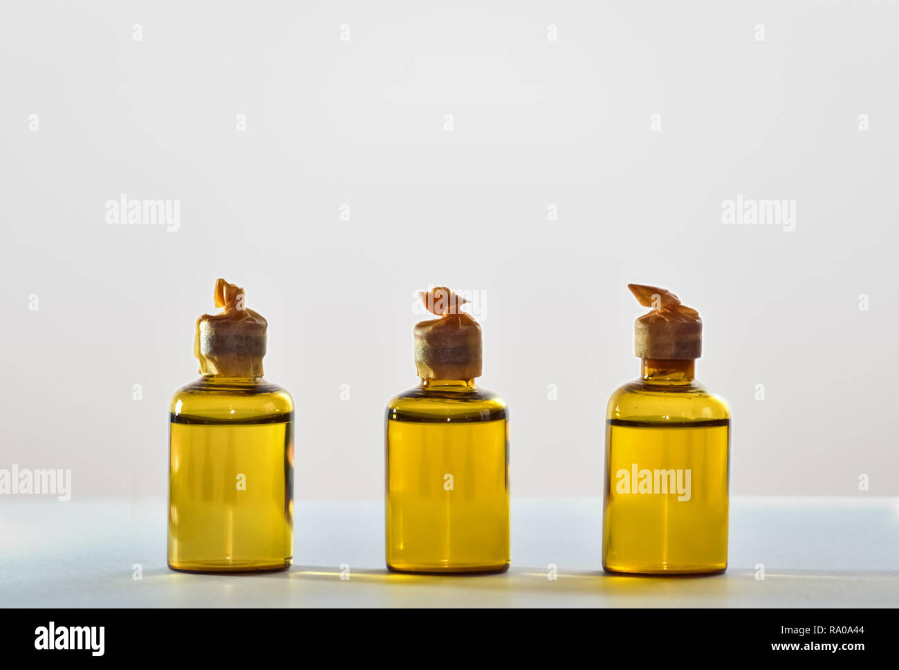 Three small yellow bottles full of chemicals on bright background Stock ...