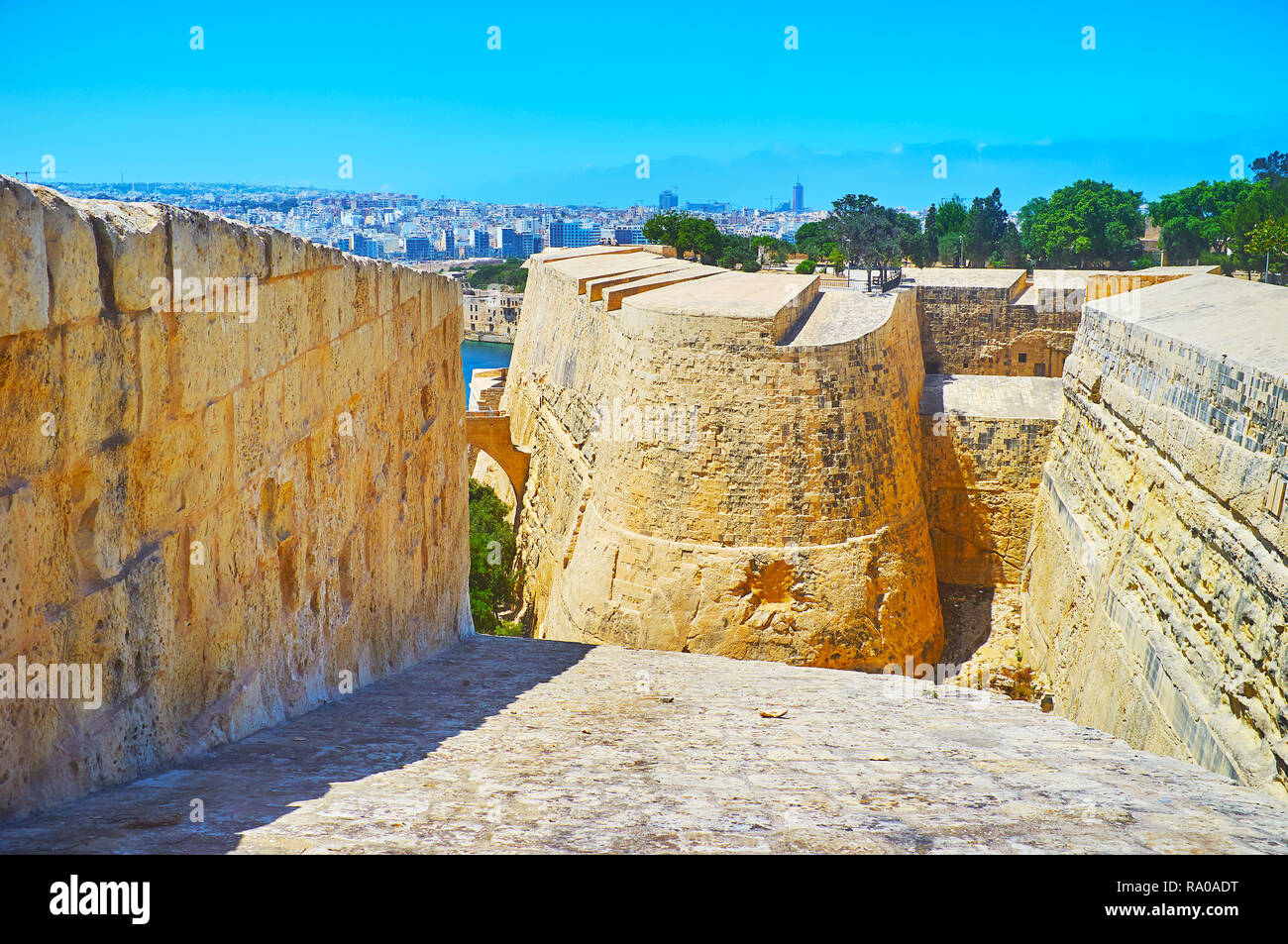The massive walls of St Michael's Bastion, topped with lush greenery of ...