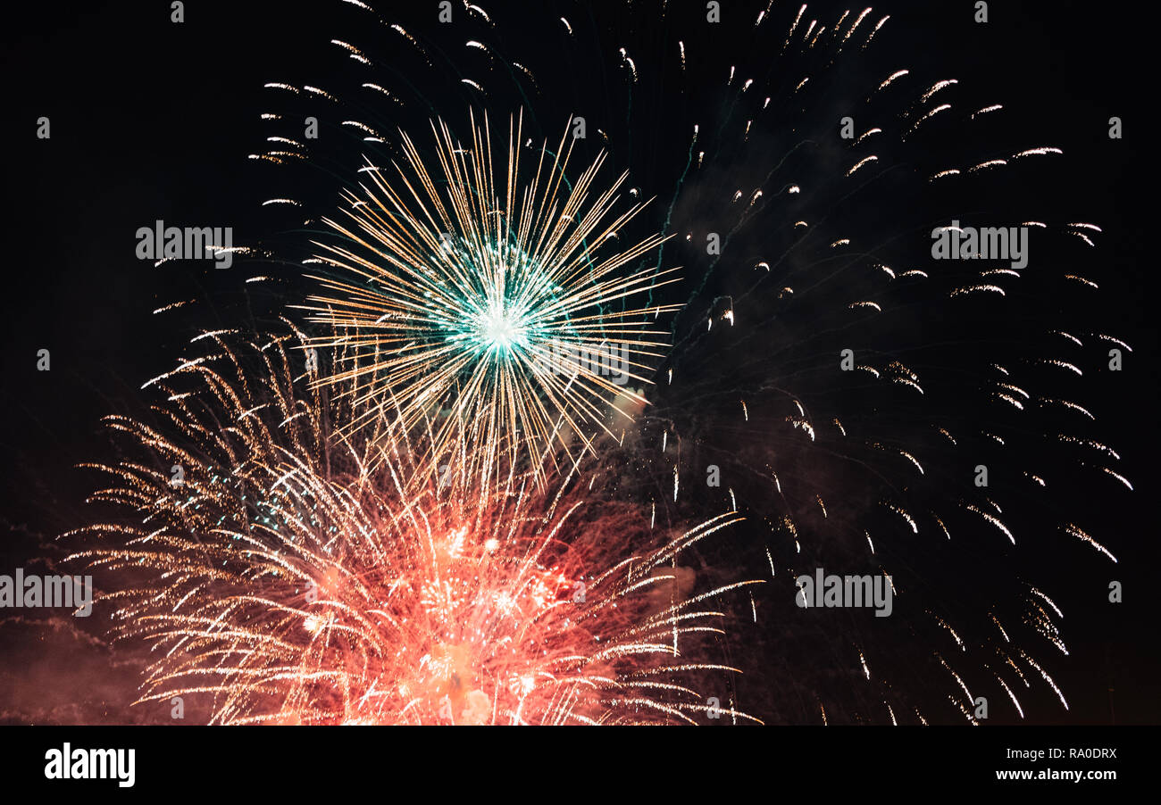 Multicolored shiny fireworks explode in dark night sky Stock Photo - Alamy