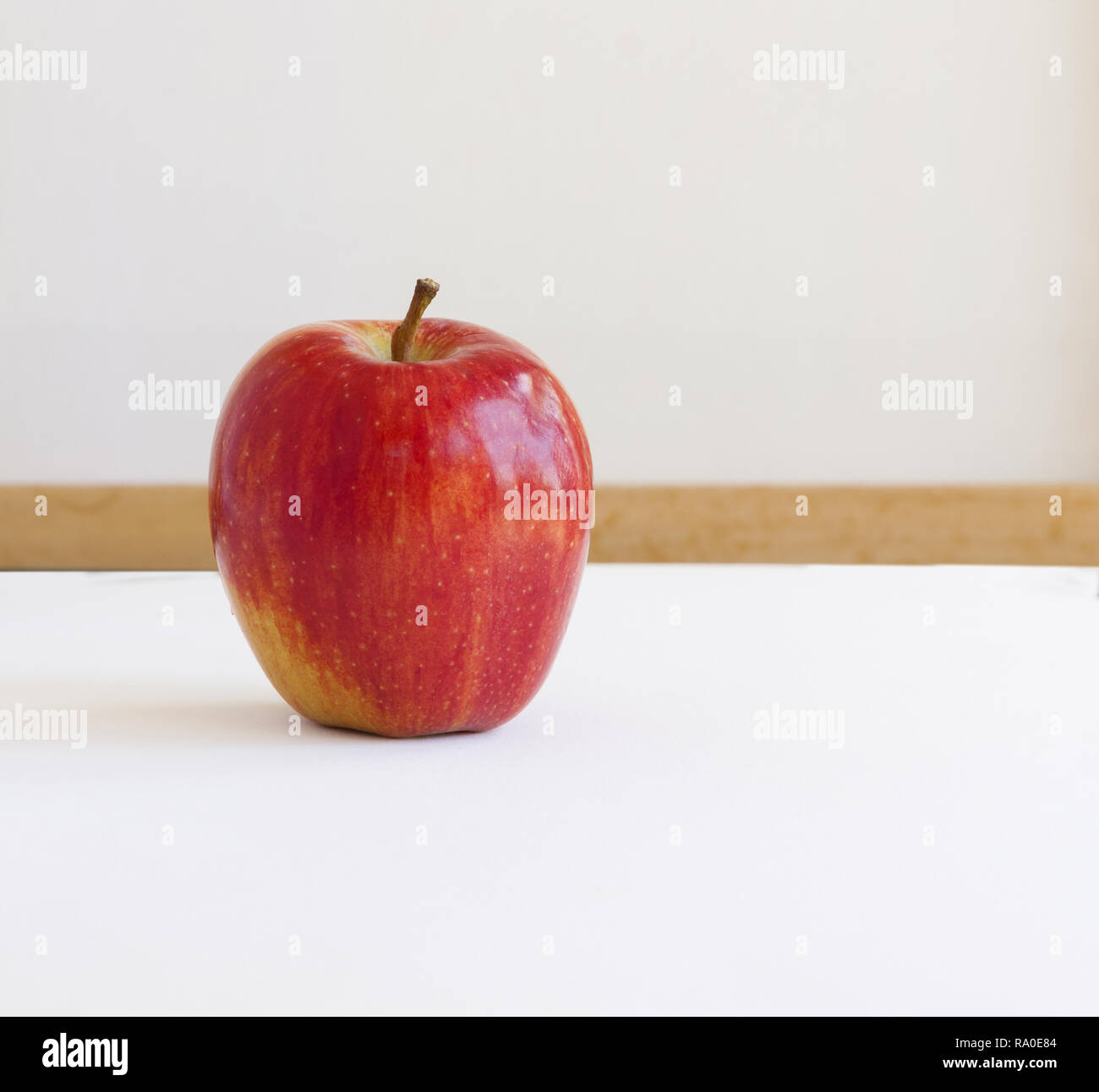 Red apple with white area and wood strip Stock Photo - Alamy
