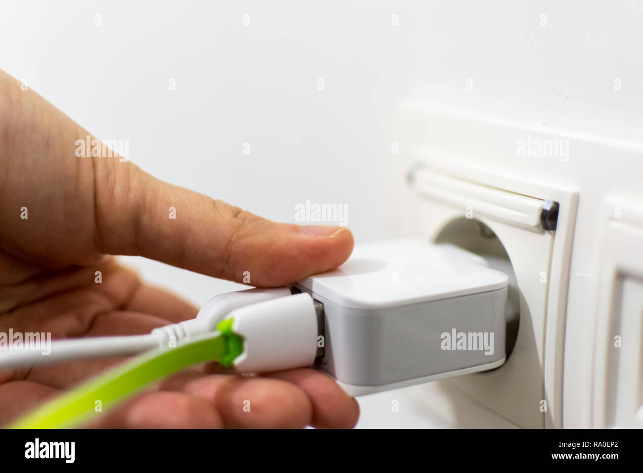 Girl putting phone charger with two connected cable into the socket ...