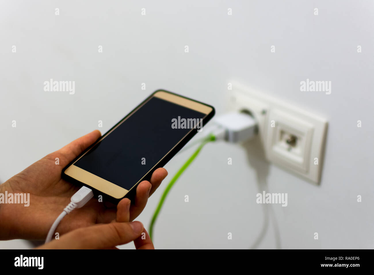 Woman holding mobile phone and trying to plug in charger Stock Photo ...