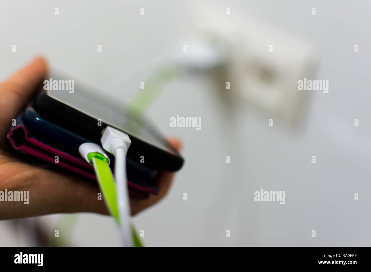 Two mobile phones charging plugged into the charger Stock Photo - Alamy