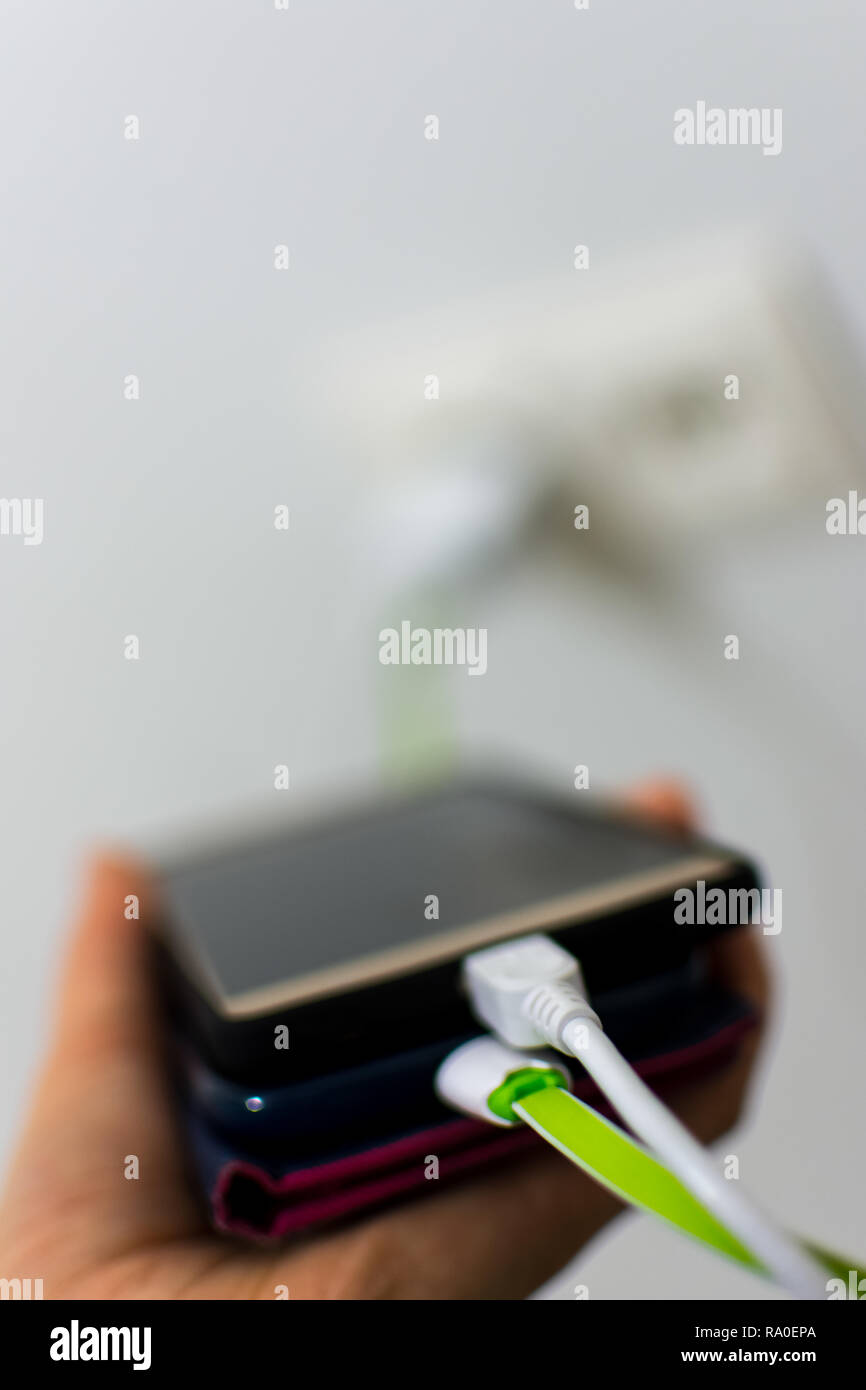 Two mobile phones charging plugged into the charger Stock Photo - Alamy