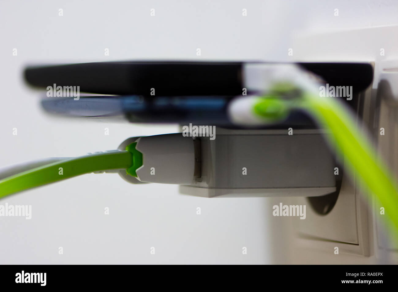 Two mobile phones charging plugged into the charger Stock Photo - Alamy