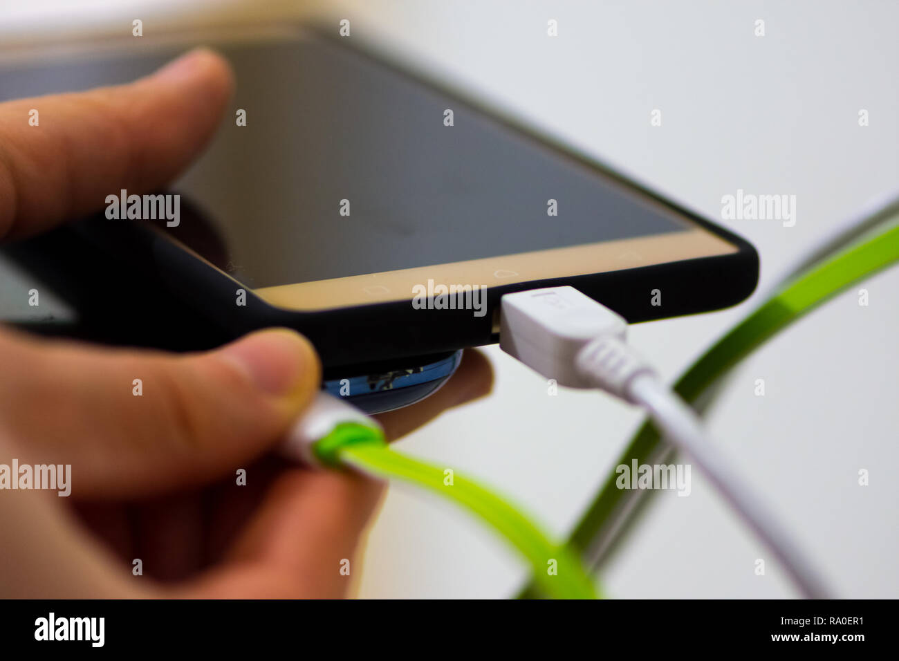 Two mobile phones charging plugged into the charger Stock Photo - Alamy