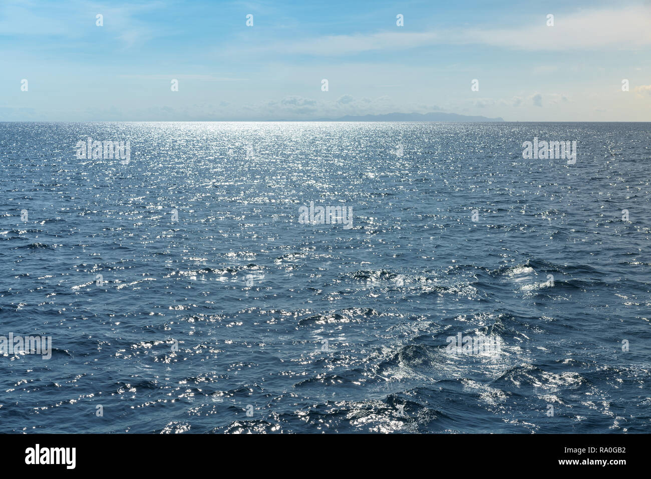 Calm day in the ocean with a blue sky Stock Photo - Alamy